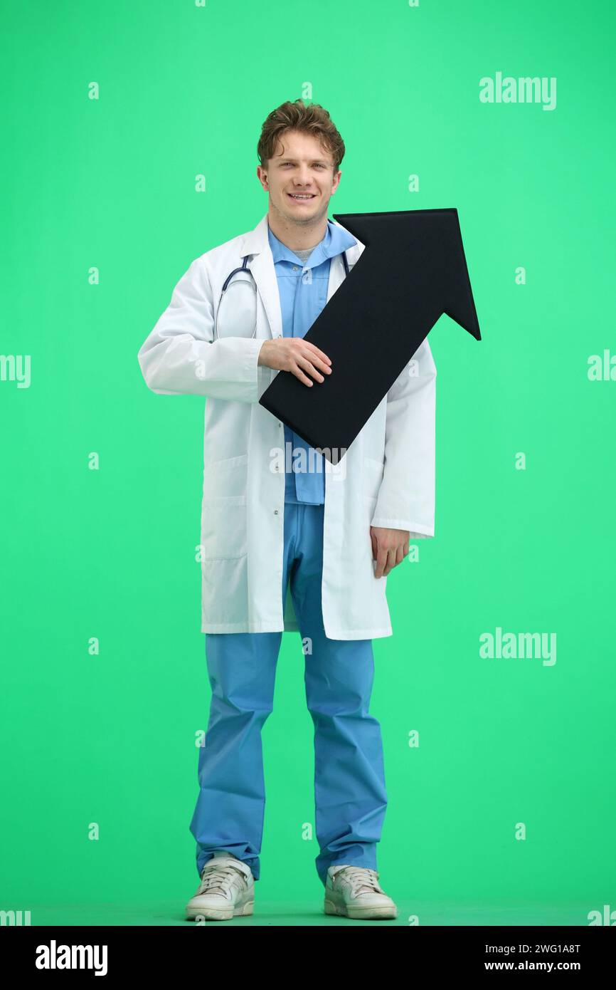 The doctor, in full height, on a green background, points with an arrow ...