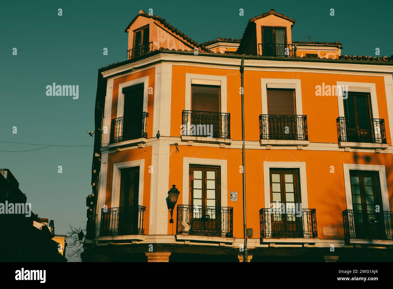 An old orange building facade against dark blue sky in sunny light ...