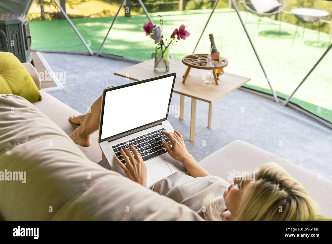 Woman working on laptop geo dome tents. Green, blue background. Cozy, camping, glamping, holiday ...