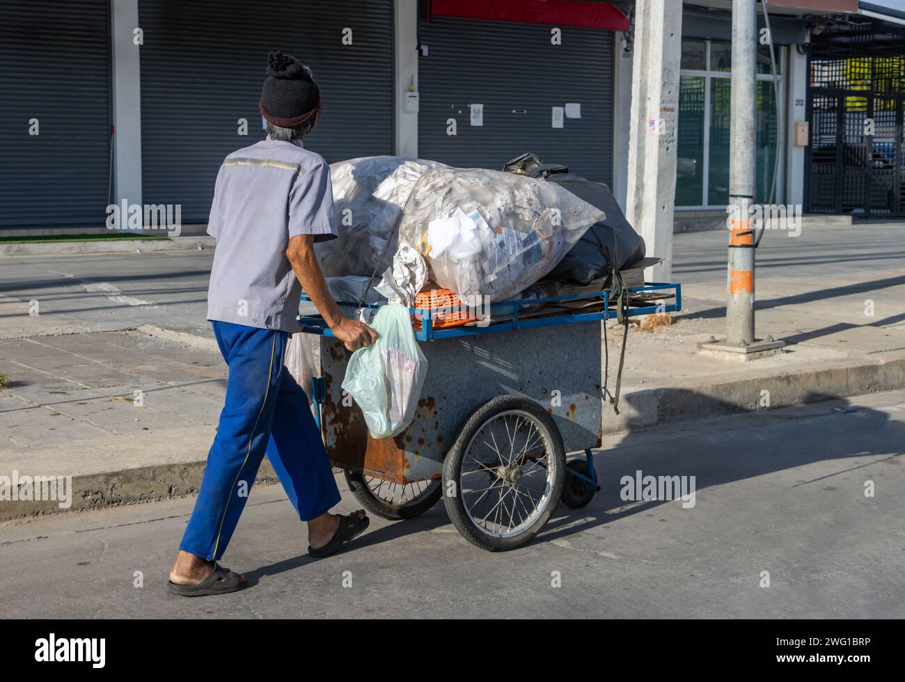 A man pushing a trolley with a load of recyclable material Stock Photo ...
