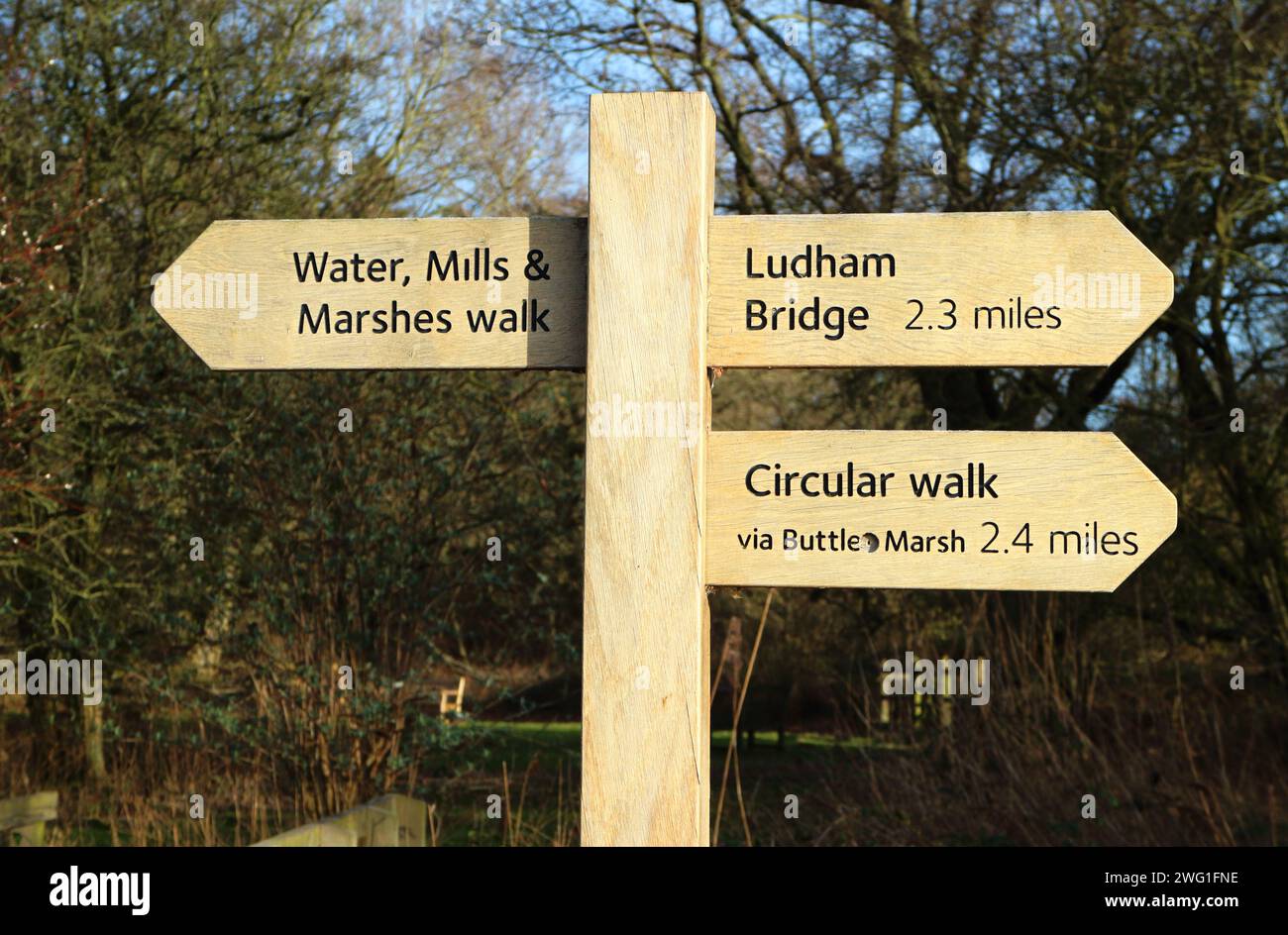 A finger post sign with locations and distances on the footpath by the ...