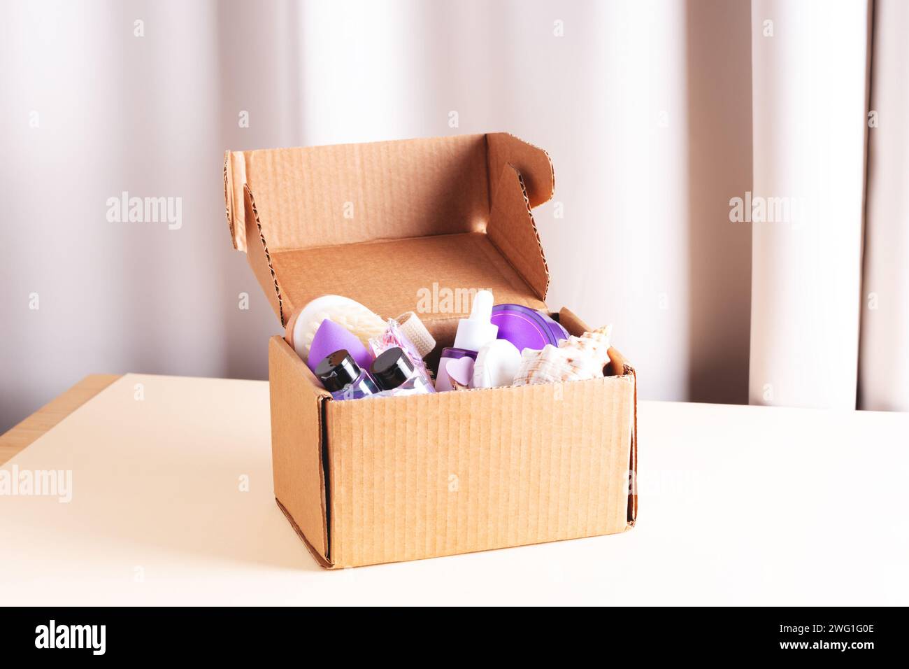 Open cardboard beauty box with various body care and skin care sample ...