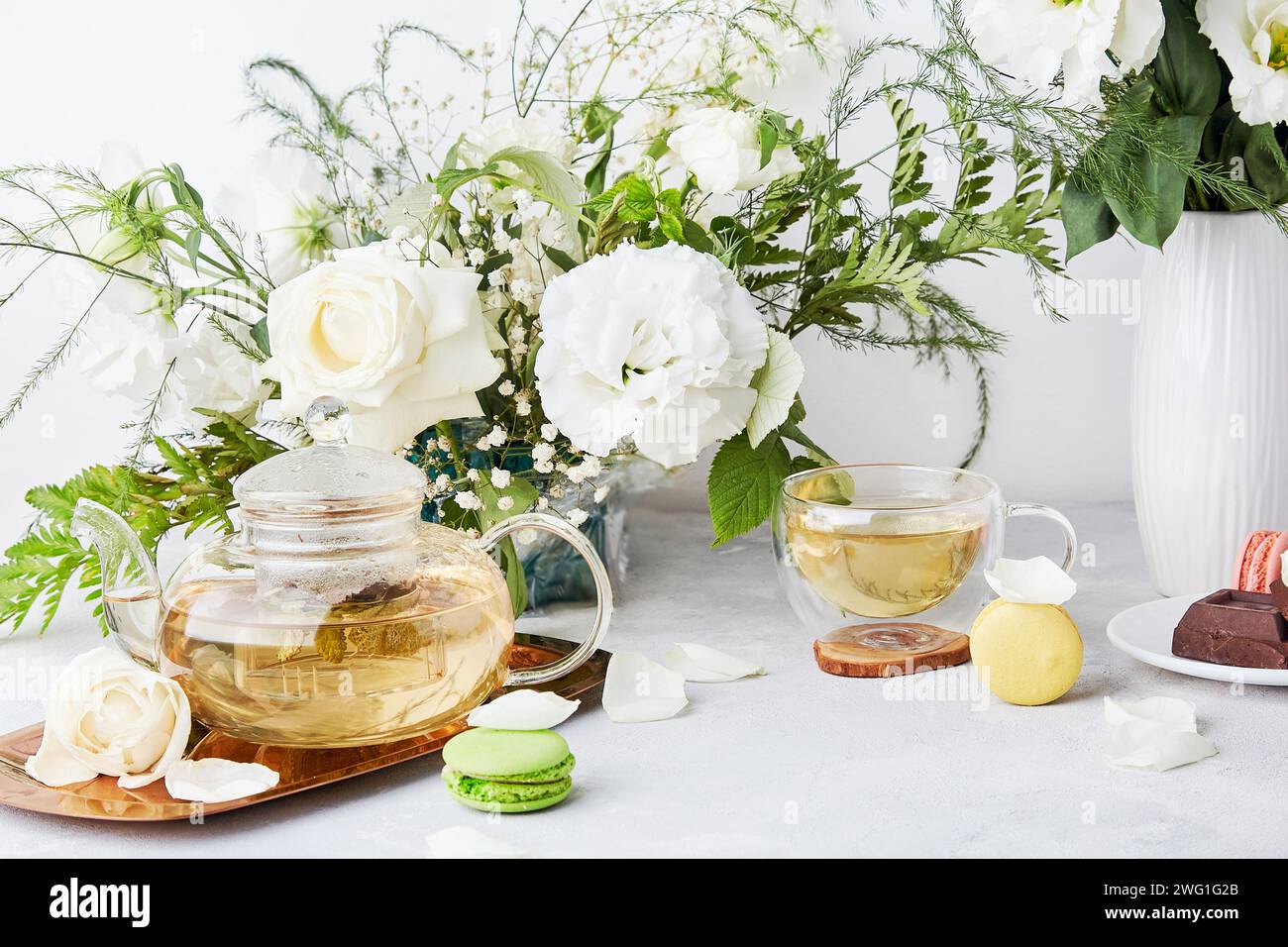 Aesthetic table setting. Green tea, macaroon desserts, chocolate, white ...