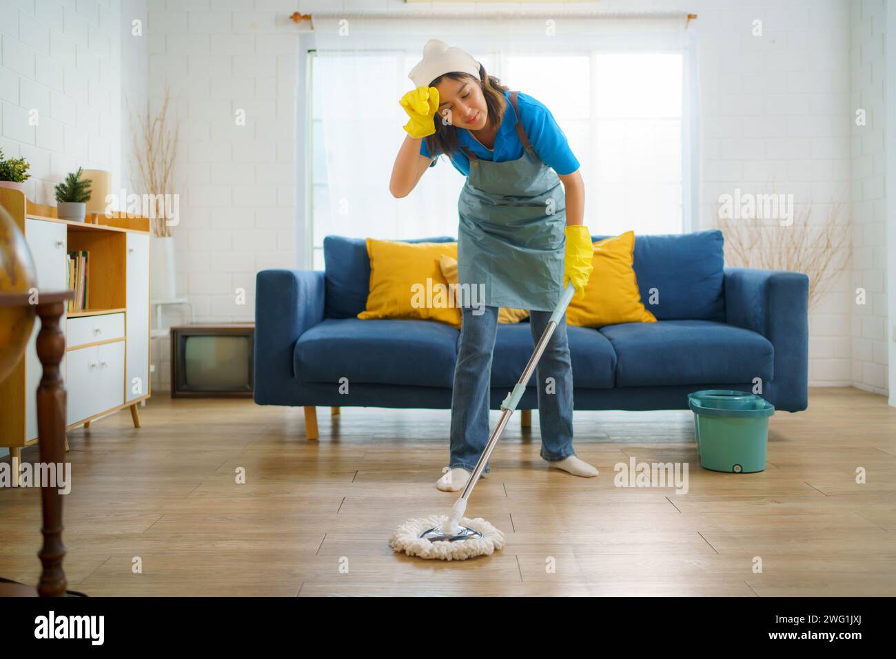 Housekeeper as she wearily clean the floor in the living room. This ...