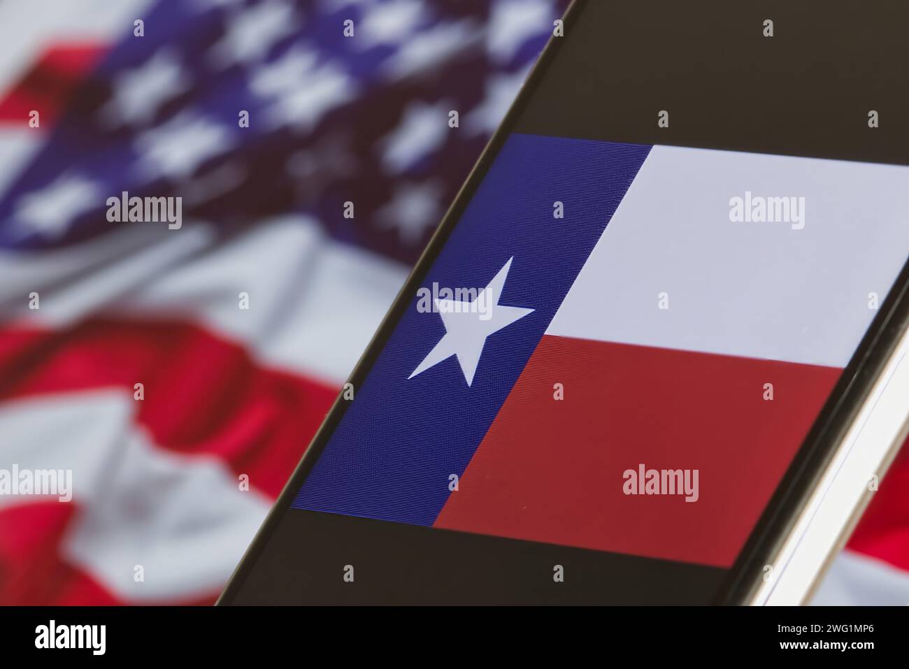A Texas flag is displayed on the smartphone screen with the American ...