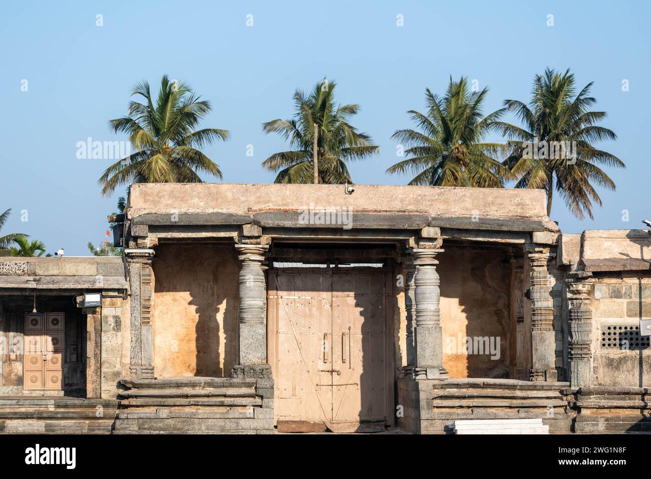 A stone structure with columns surrounded by palm trees at the ancient ...