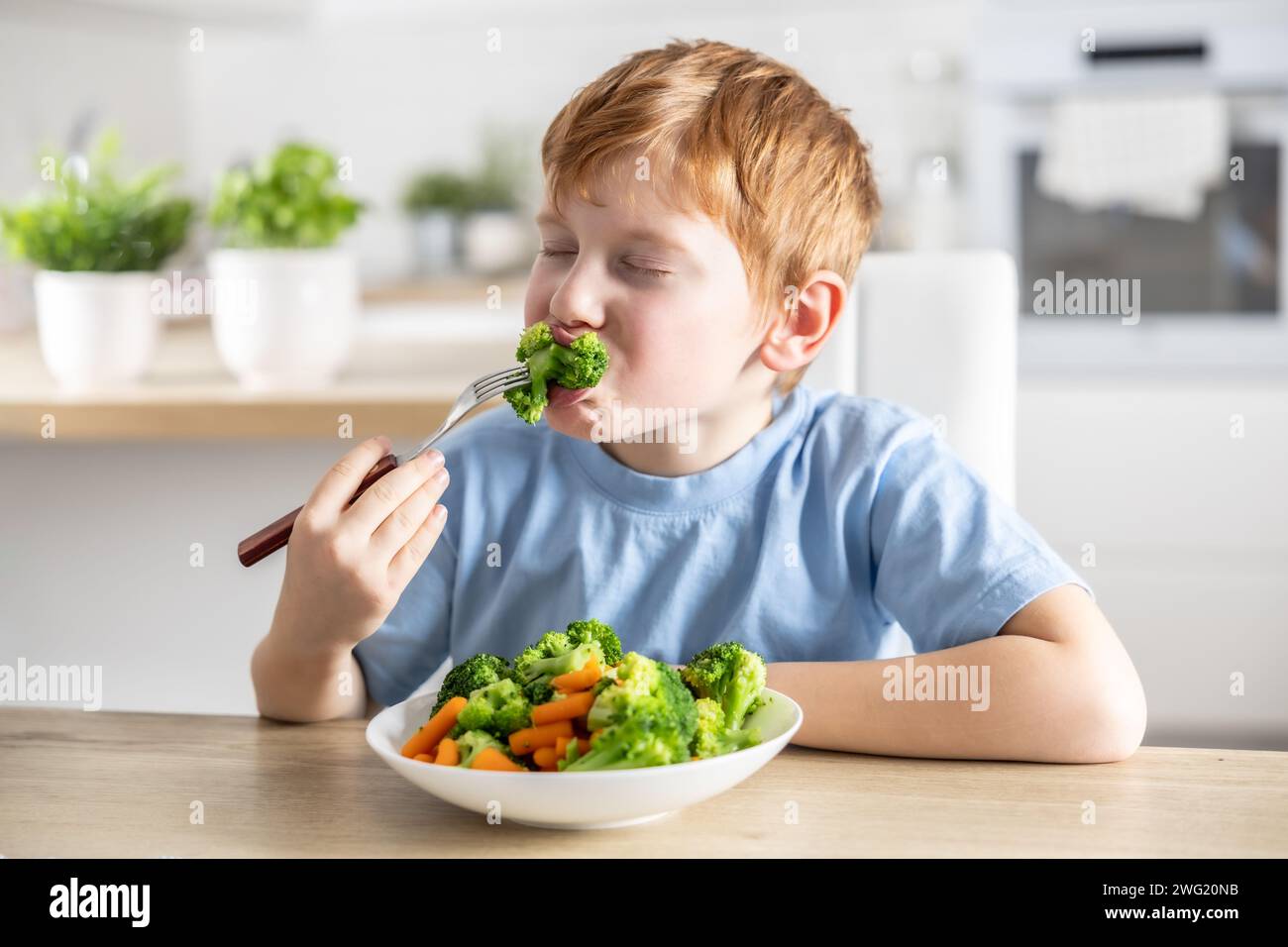 A little boy is having lunch and eating broccoli Stock Photo - Alamy