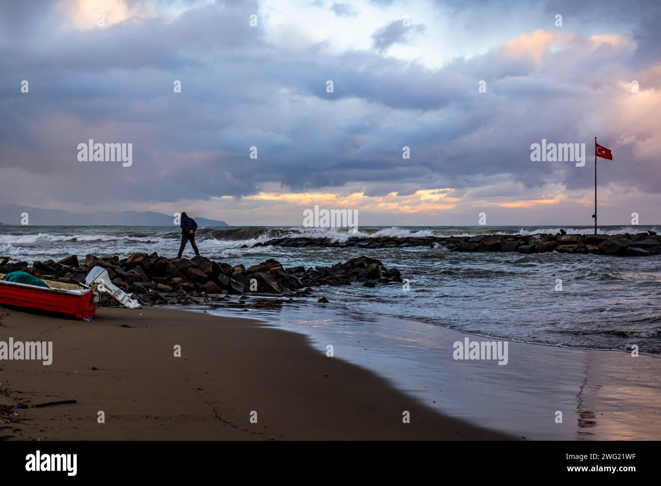 A man standing on coastal rocks looking at the sea. Ordu, Turkey Stock ...