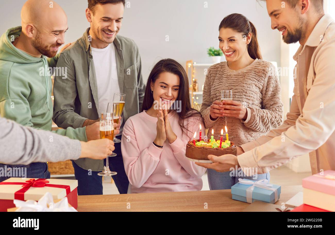 Happy friends congratulating a young smiling girl on her birthday ...