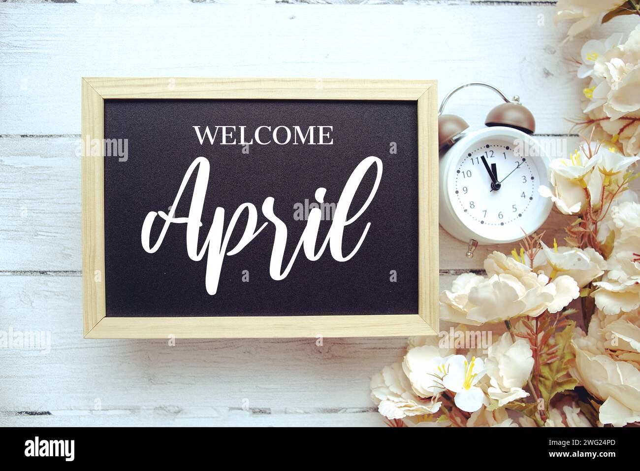 Welcome April text message with flower decoration on wooden background ...
