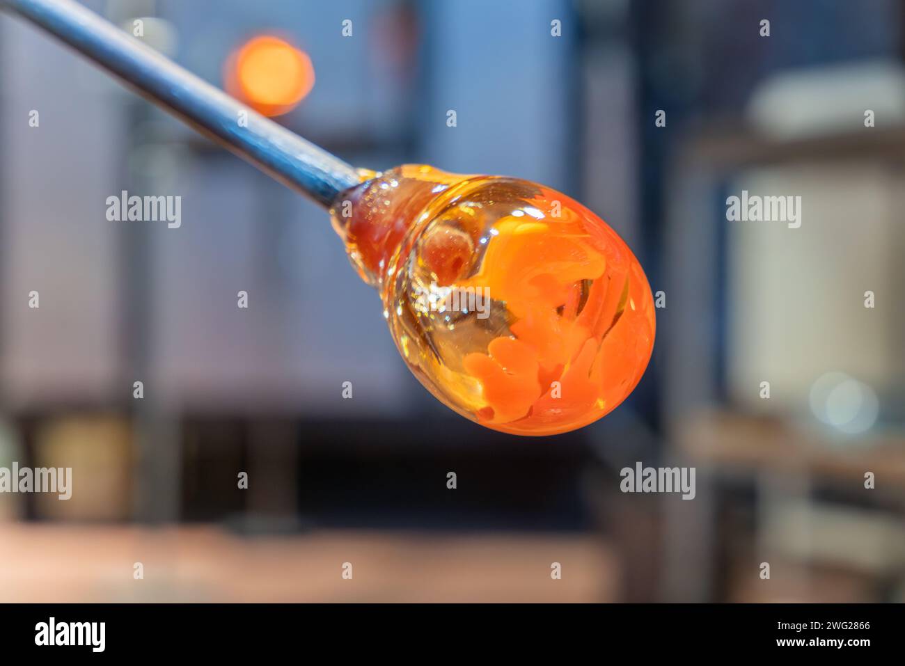Glassblowing. Molten glass on edge of pontil. Manual process of glass ...