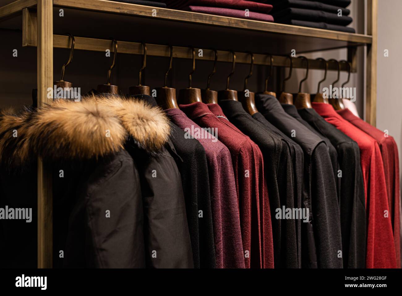 wardrobe with men's clothes in dark colors. jacket, down jacket, shirt ...