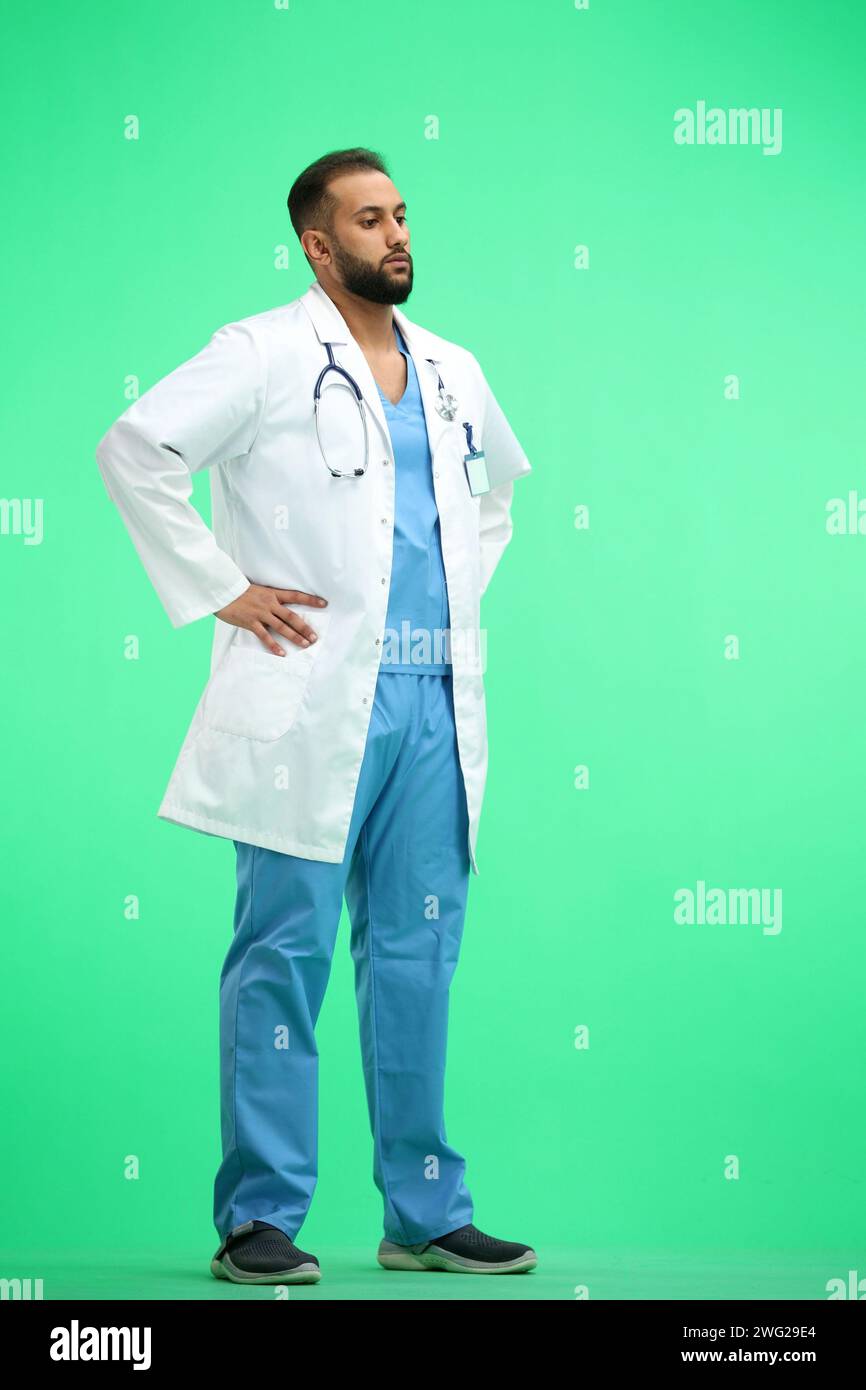 Doctor, full-length, on a green background, hands on hips Stock Photo ...