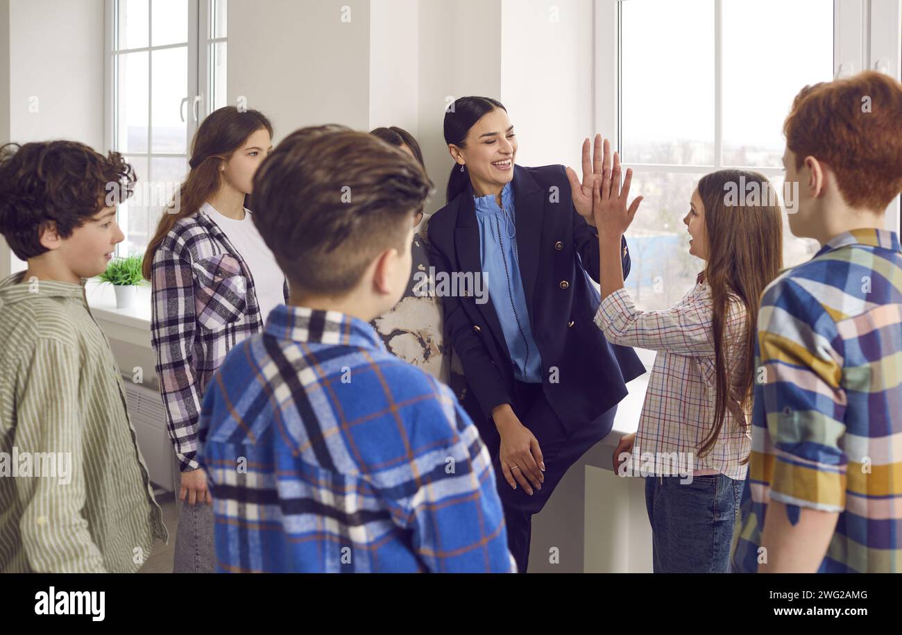 Happy female teacher giving high five to girl student Stock Photo - Alamy