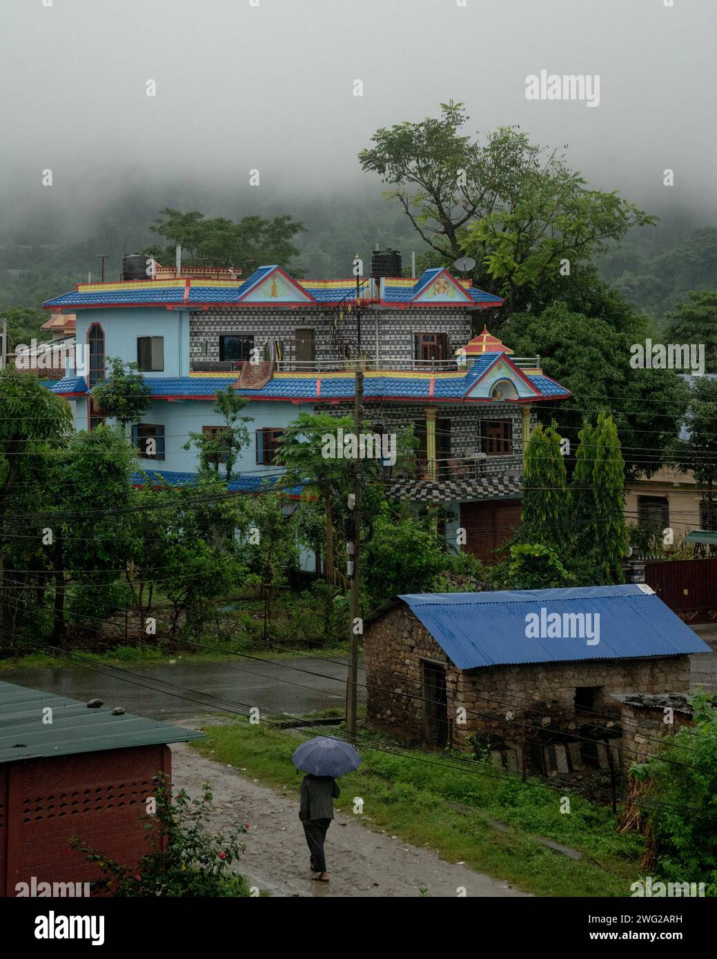 A man walks down the street with an umbrella during the monsoon season ...