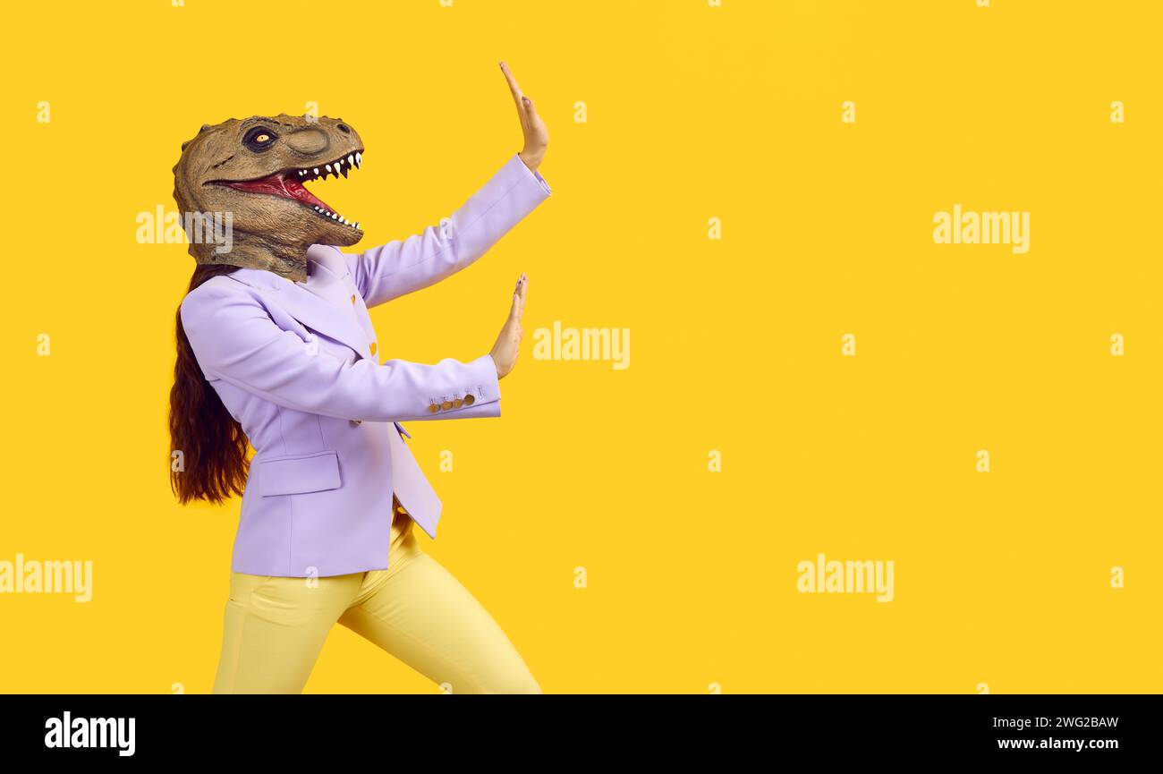 Elegant woman with with t-rex mask gesturing with her hands pointing ...