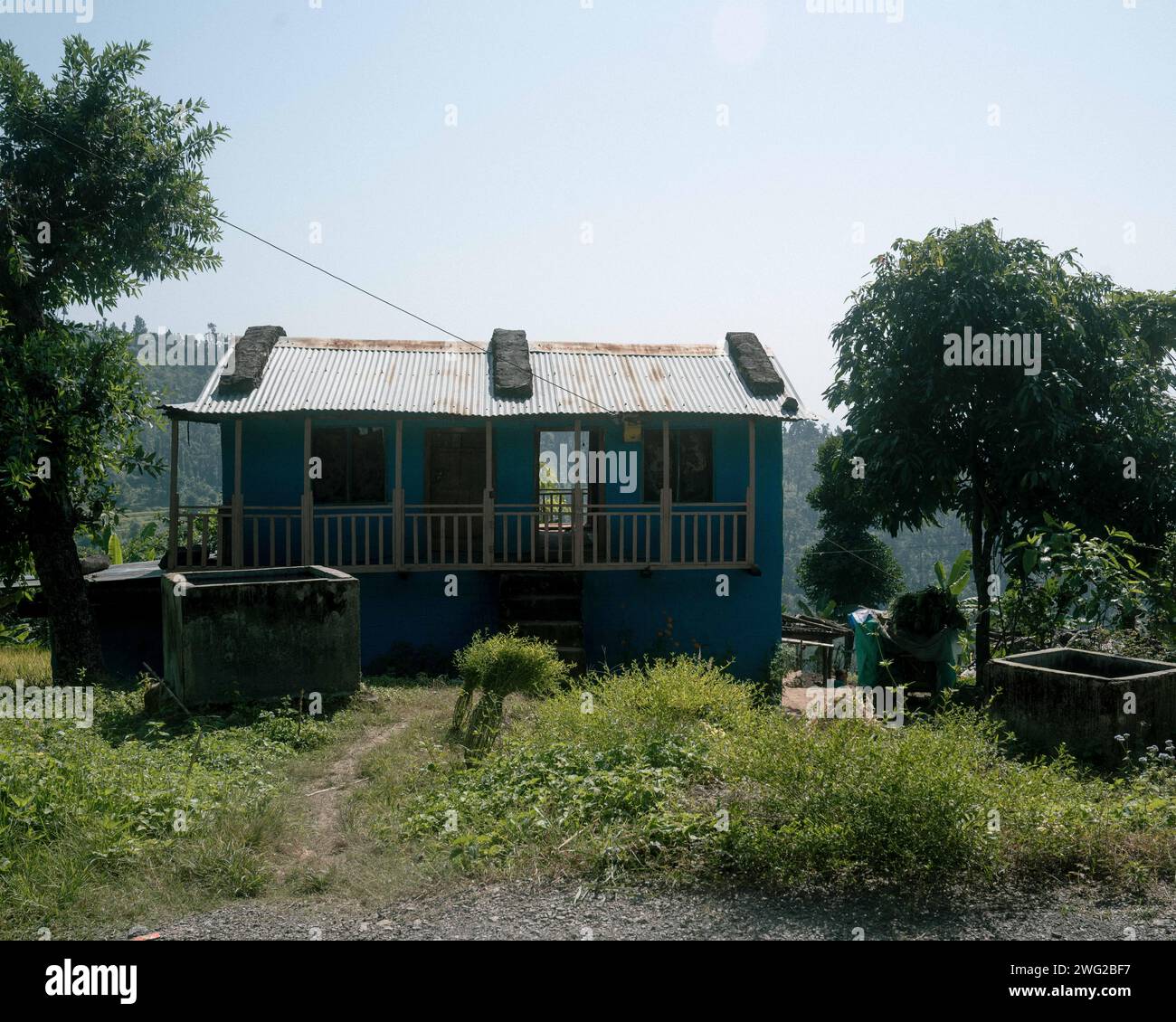 A typical mud brick, tin roof, Nepalese house in the mountains, in ...
