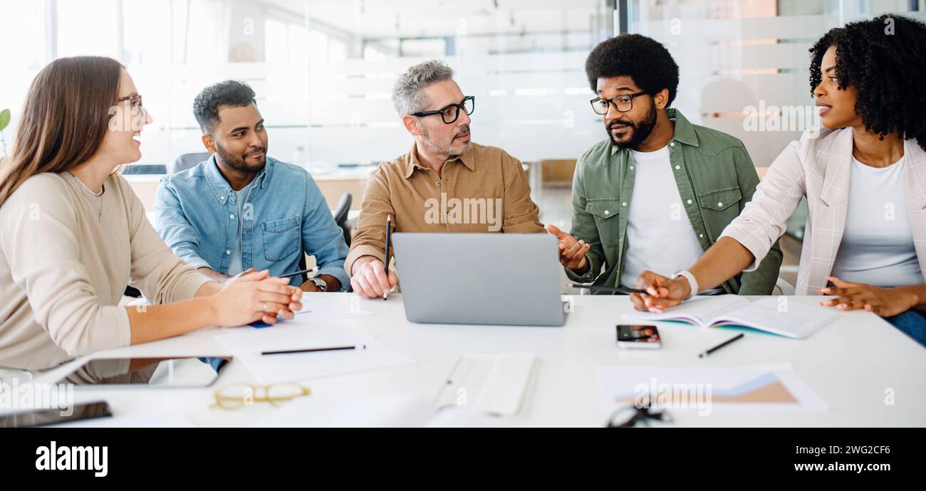 A lively discussion unfolds among four colleagues around a table, with ...