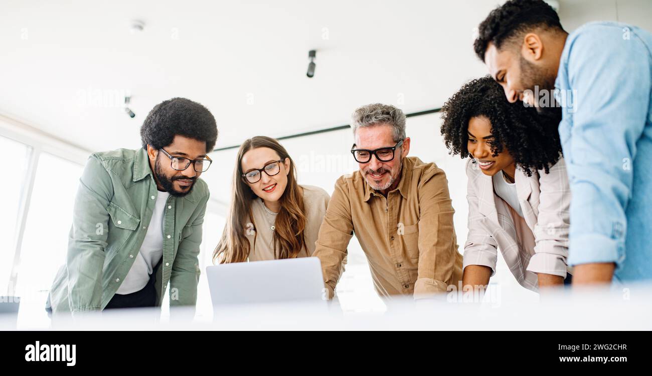 A diverse team of colleagues enthusiastically engages with content on a ...