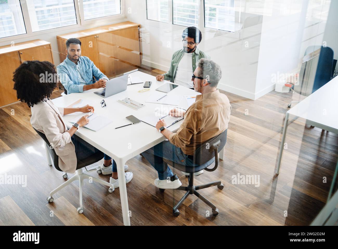 Top view of collaborative meeting shows diverse team engaging in strategic discussion at an ...