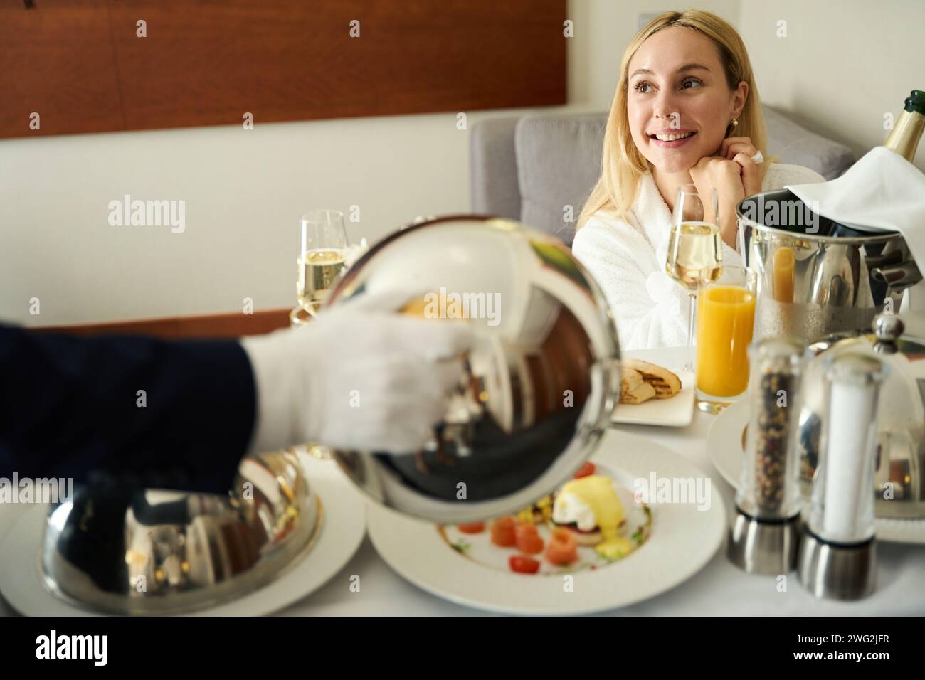 Waiter in white gloves serves breakfast to a hotel guest Stock Photo ...