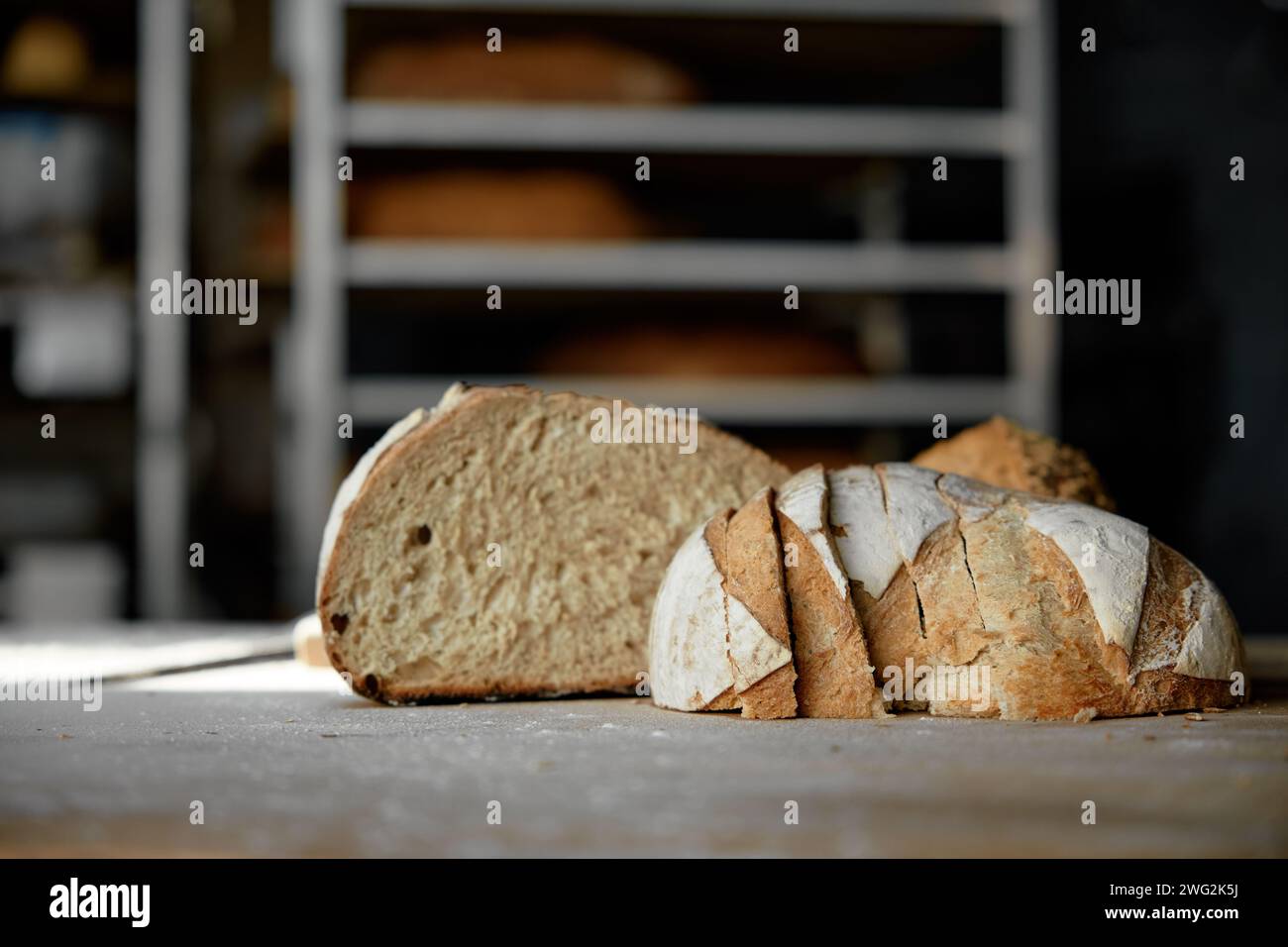 Freshly cooked artisan bread half and sliced on table bakery shop Stock ...