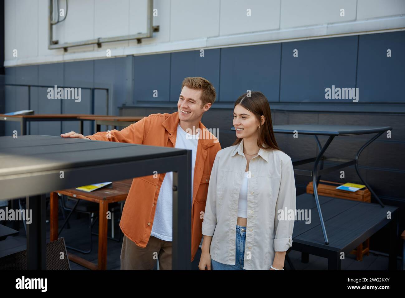 Happy loving young family couple choosing table for home at shopping ...