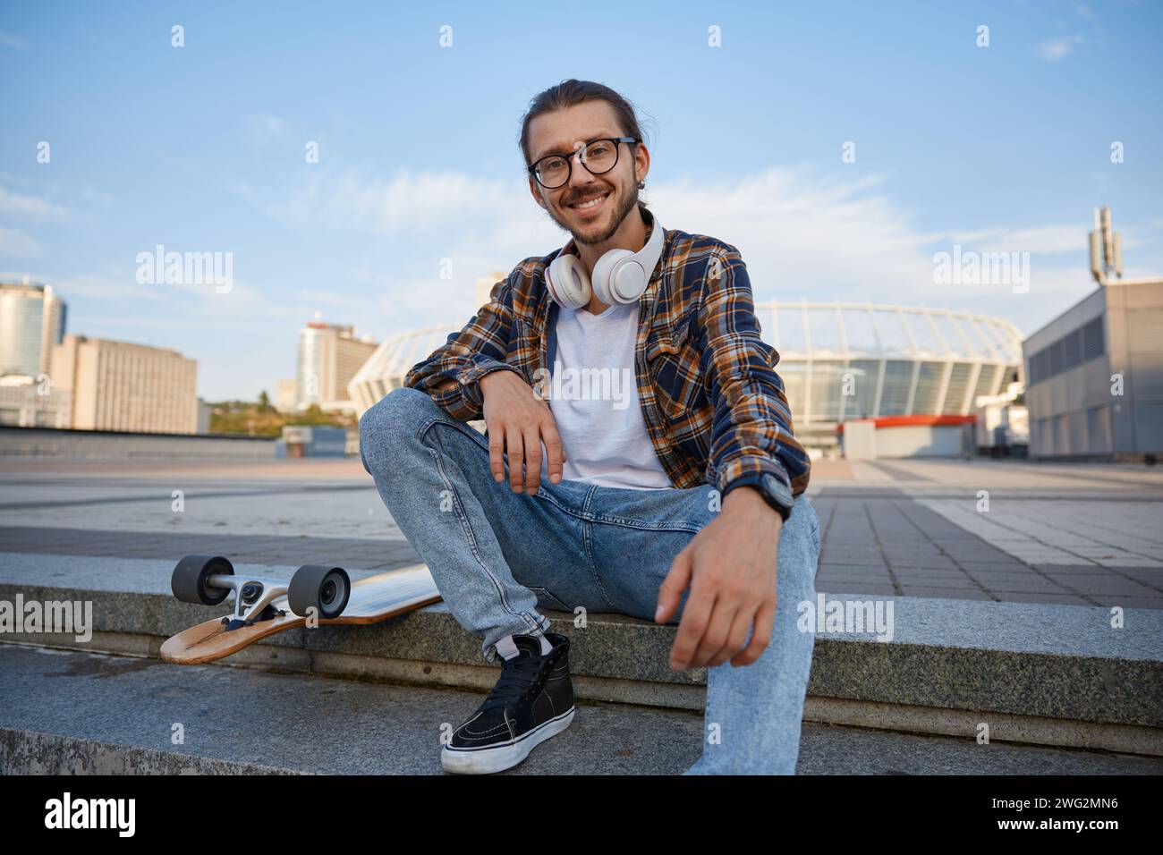 Cool guy student with longboard rest on stairs of university urban ...
