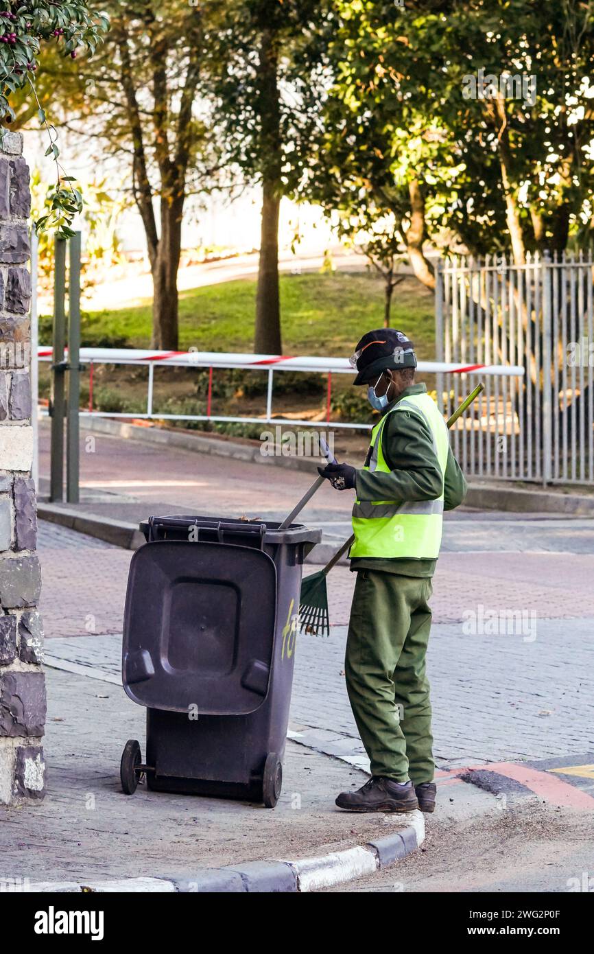 black African man sweeping streets and cleaning up, street cleaner ...