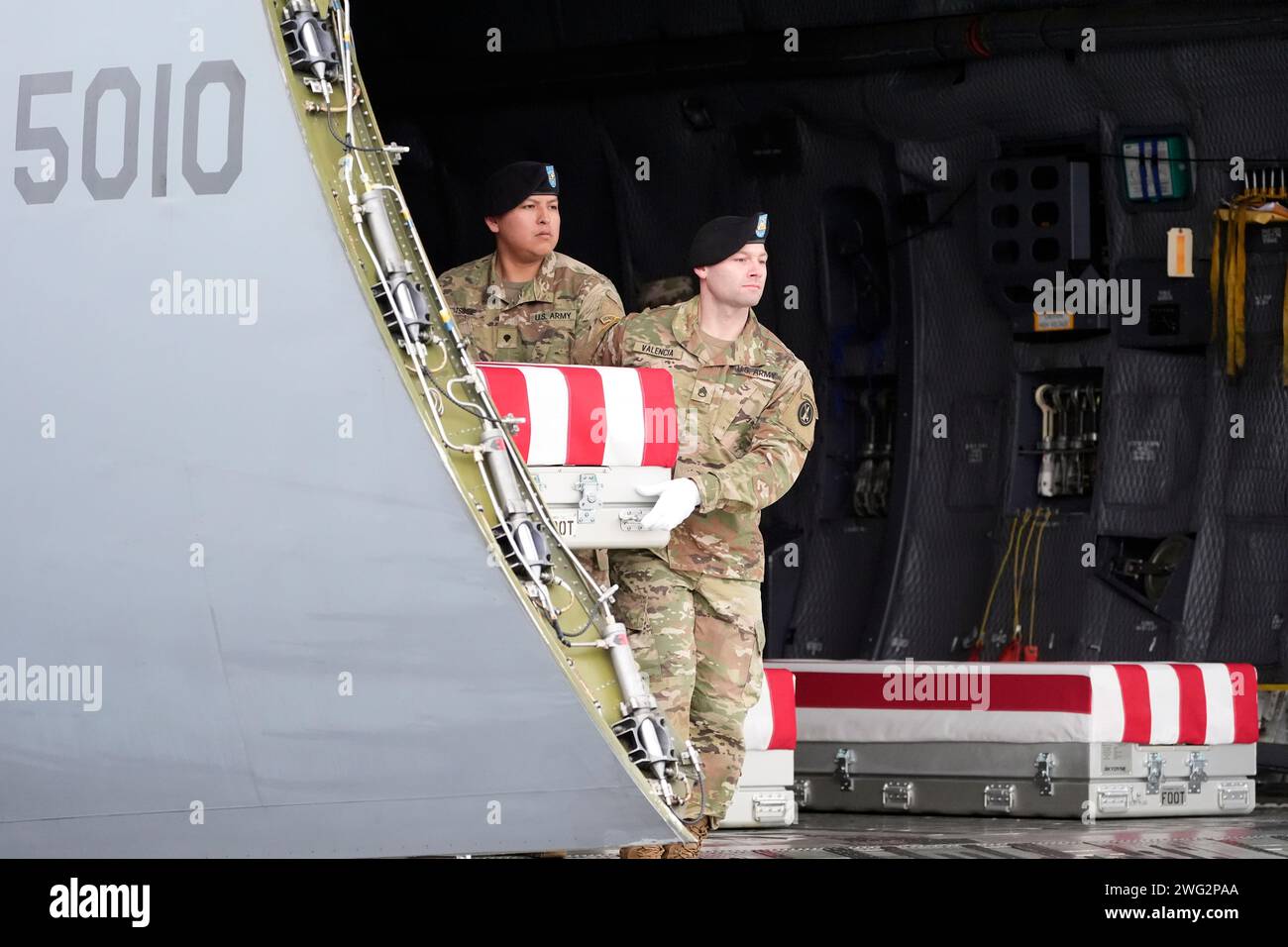 An Army carry team moves the flag-draped transfer case containing the ...