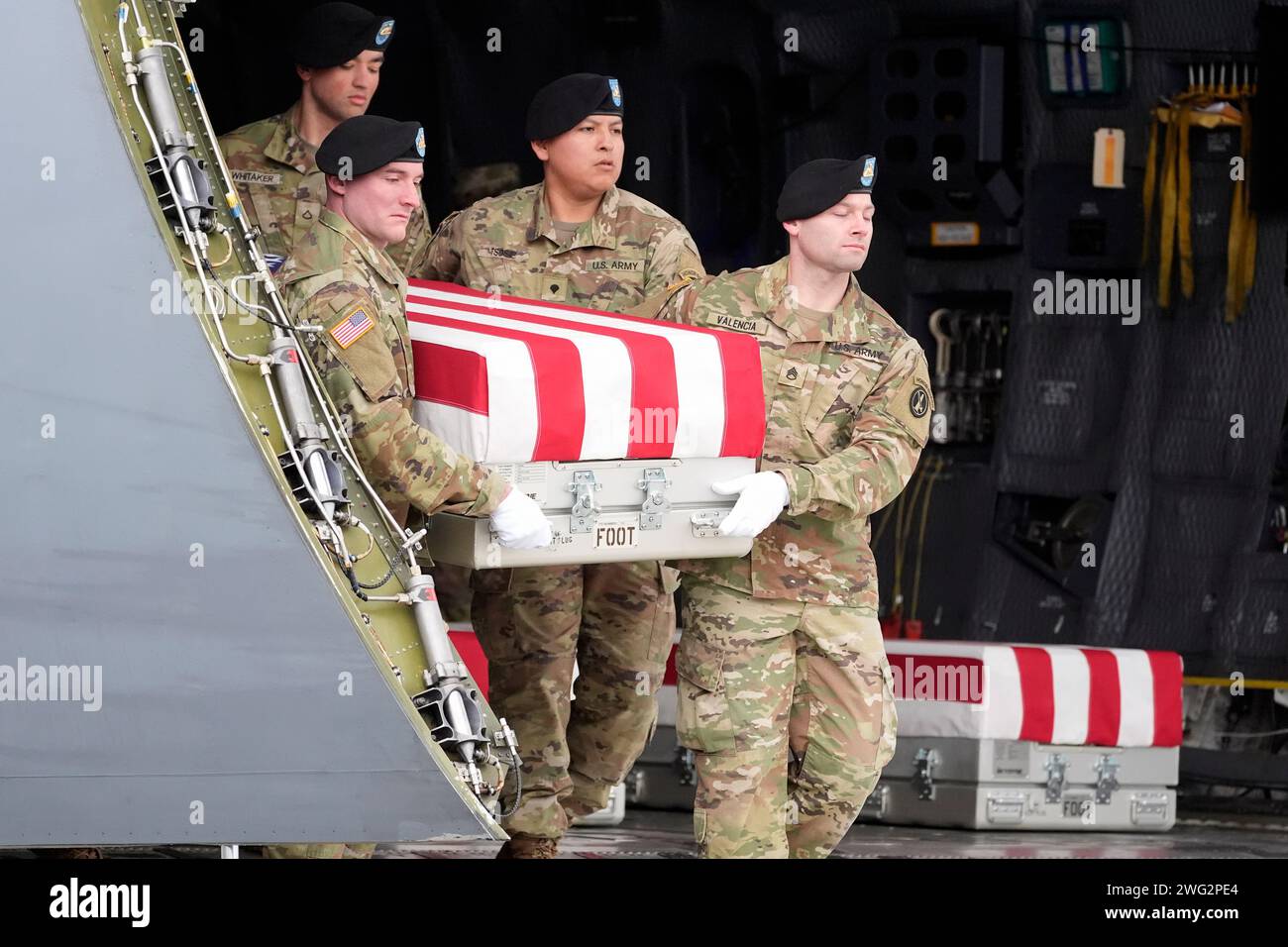 An Army carry team moves the flag-draped transfer case containing the ...