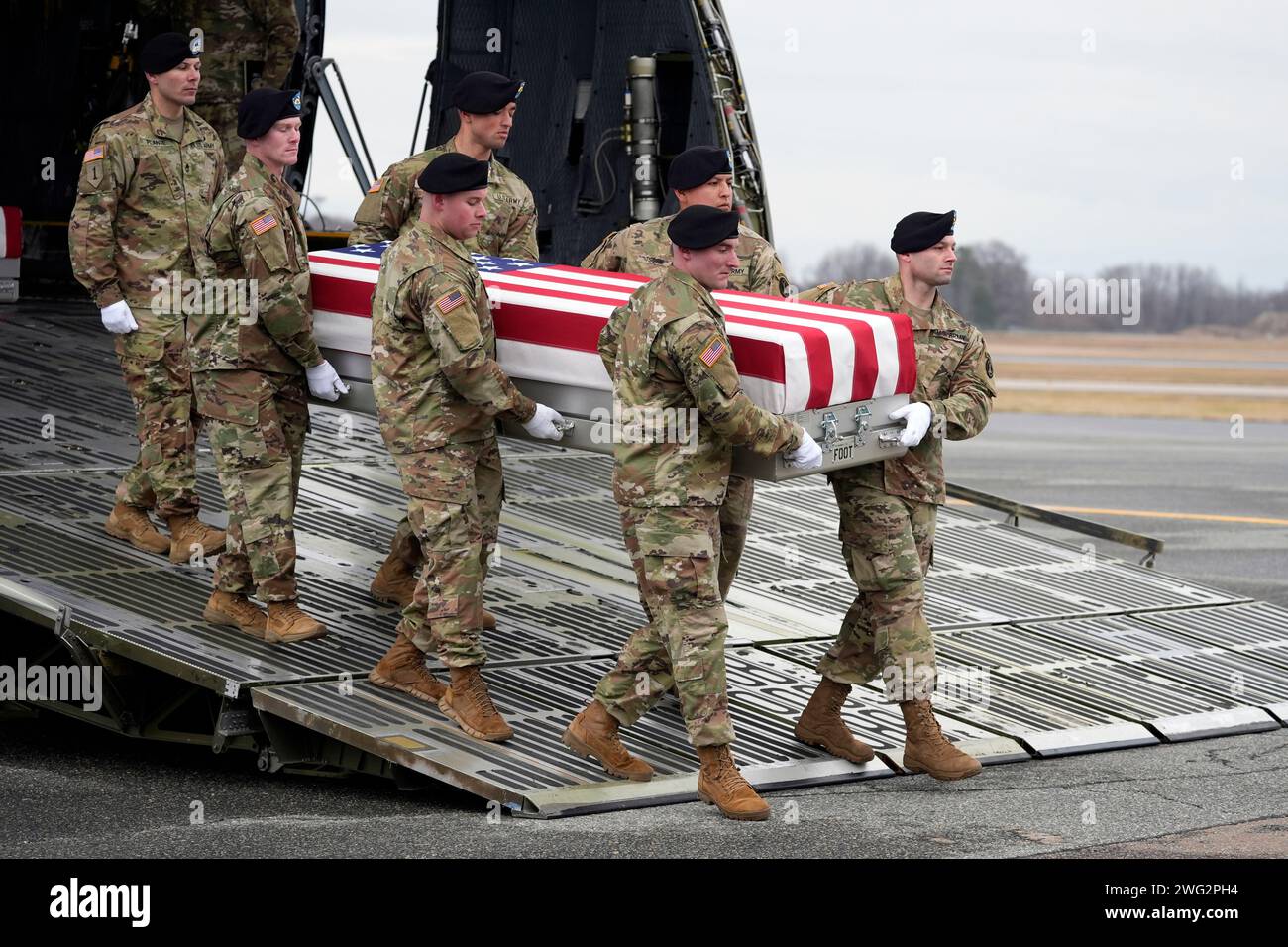 An Army carry team moves the flag-draped transfer case containing the ...