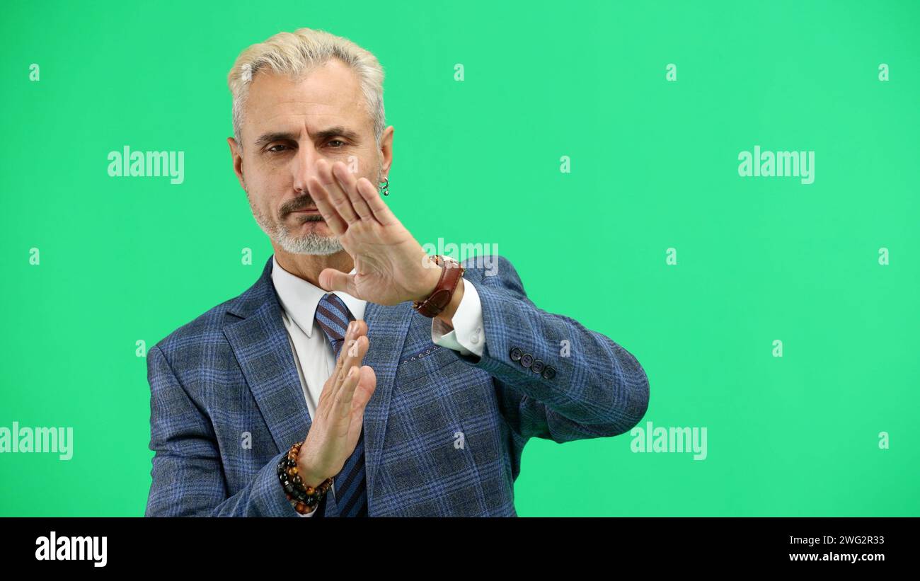 A man, close-up, on a green background, shows a pause sign Stock Photo ...