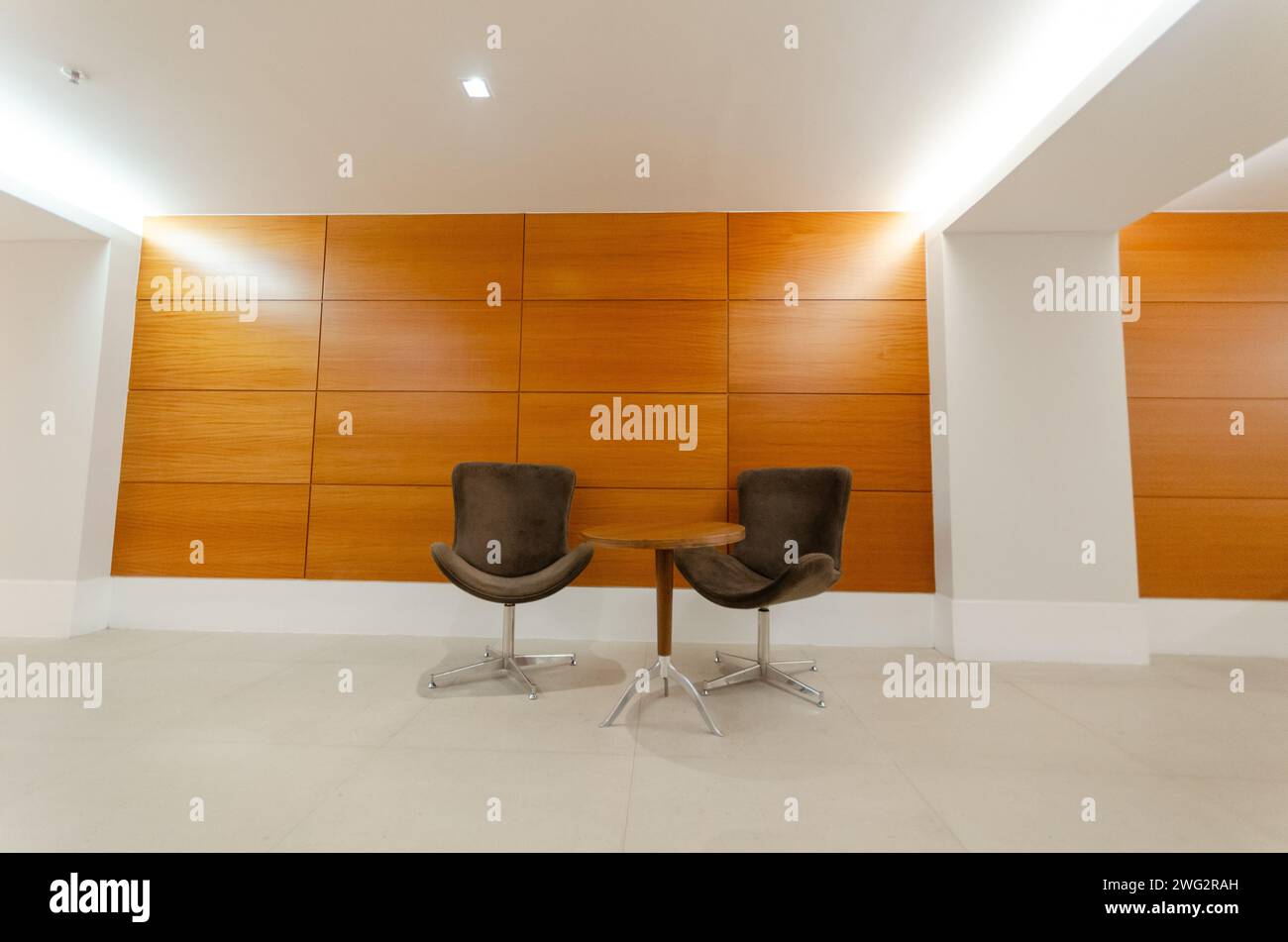 Two chairs positioned beside a coffee table in the center of a well-lit ...