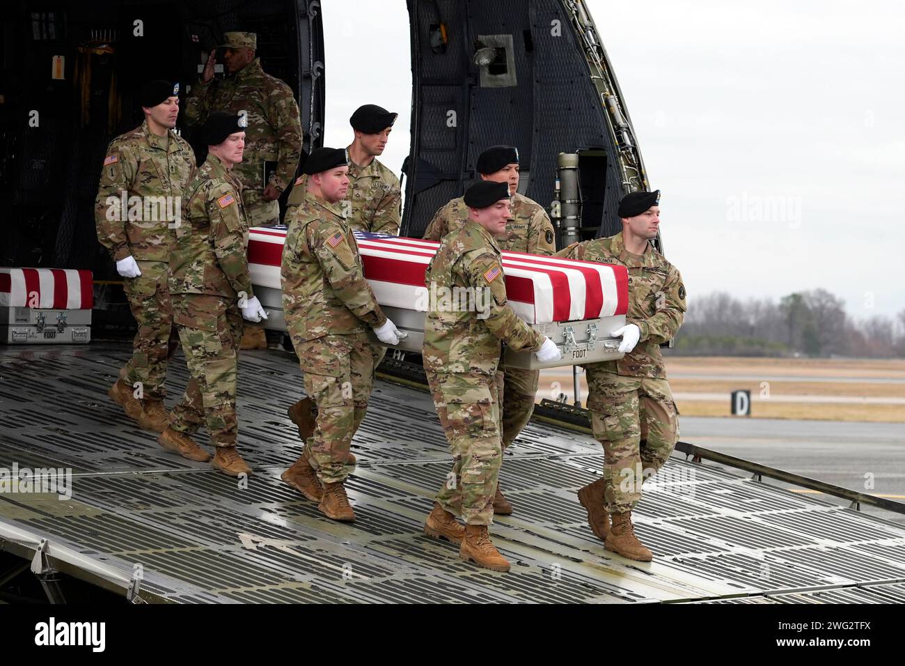 An Army carry team moves the flag-draped transfer case containing the ...