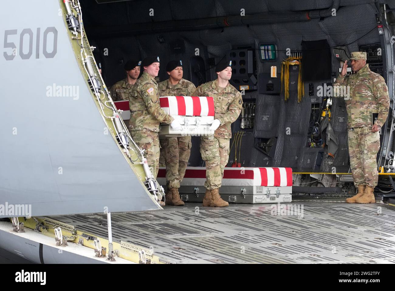 An Army carry team moves the flag-draped transfer case containing the ...