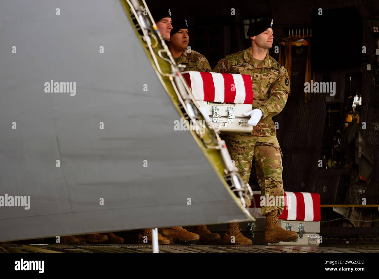 An Army carry team moves the transfer case containing the remains of U ...