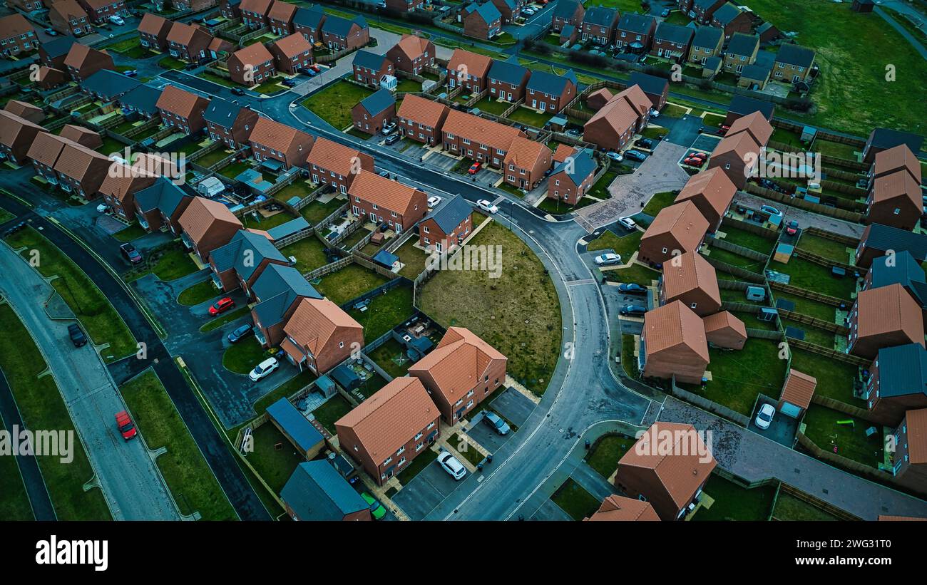 Aerial view of a suburban neighborhood at dusk with rows of houses and ...