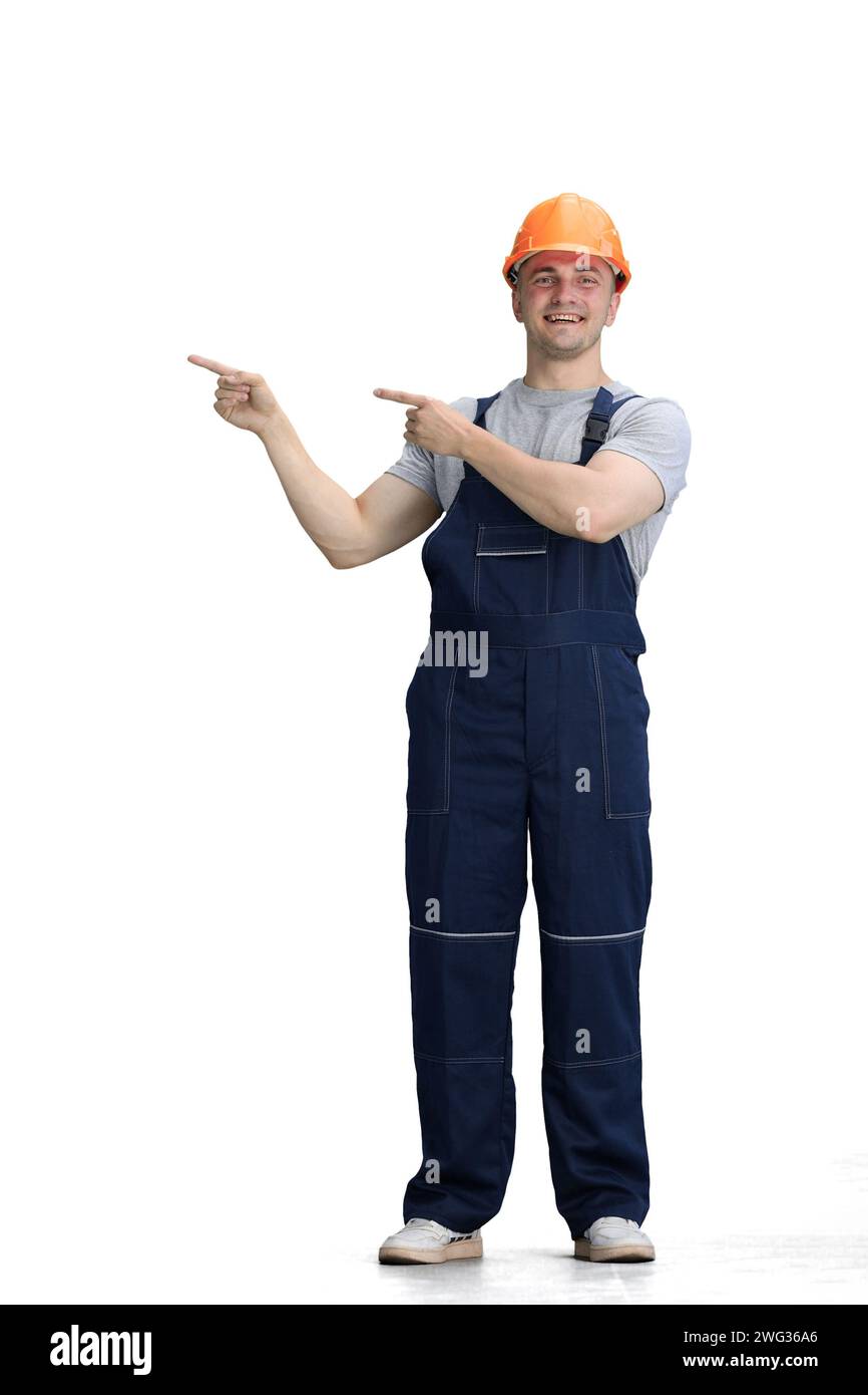 The builder, on a white background, in full height, points to the side ...
