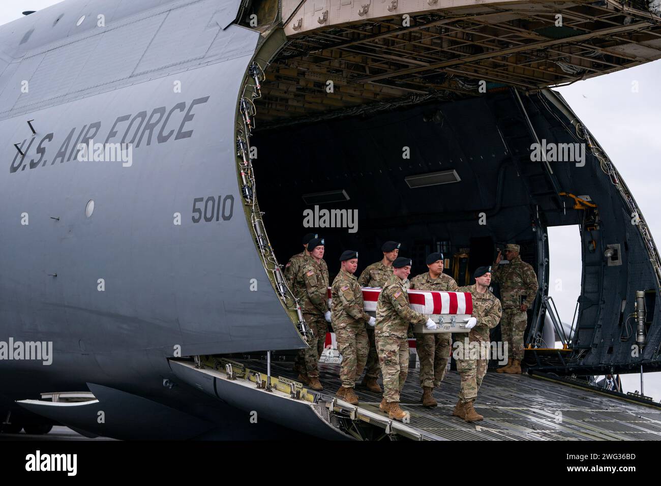 A U.S. Army carry team moves a flagged draped transfer case containing ...