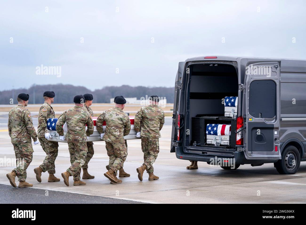 A U.S. Army carry team salutes as a transfer case carrying the remains ...