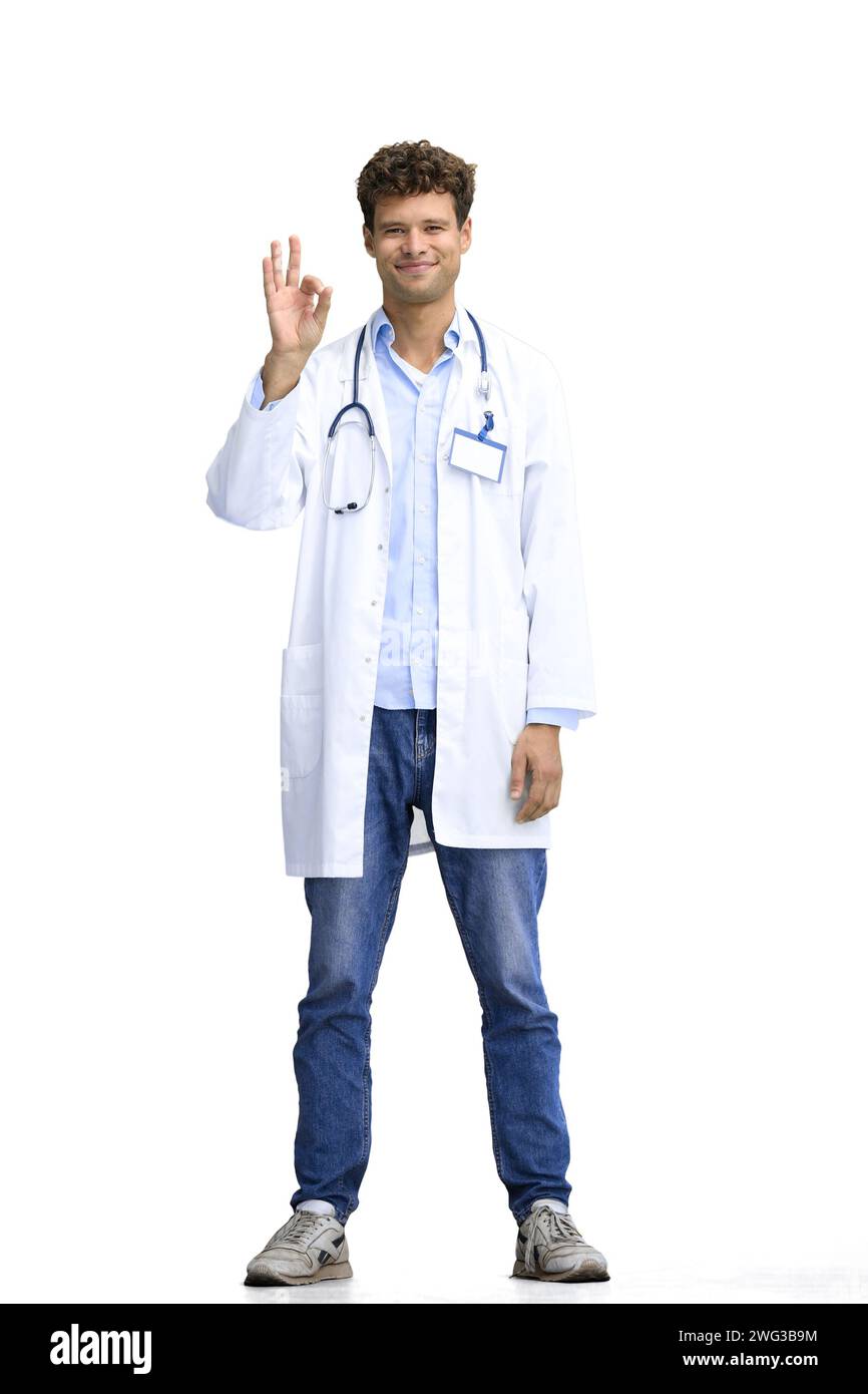 A male doctor, on a white background, in full height, shows the ok sign ...