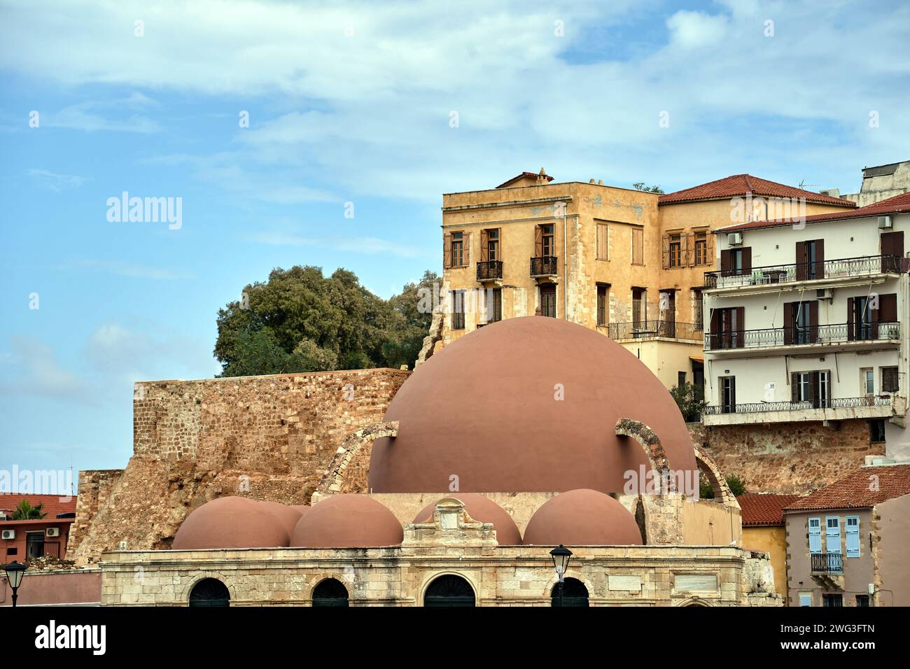 domes of a historic mosque and historic buildings in the port of Chania ...
