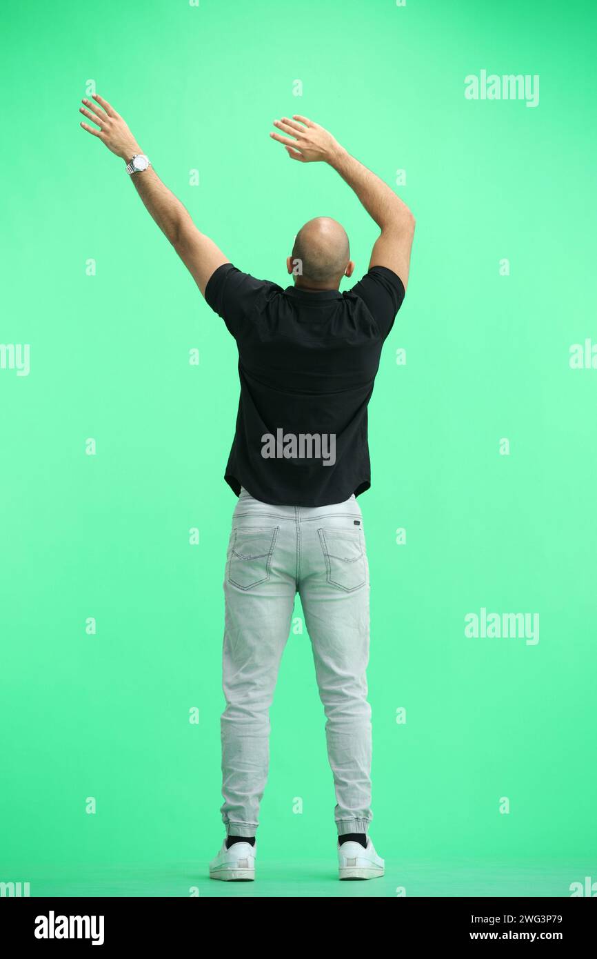 A man, on a green background, in full height, waving his arms Stock ...