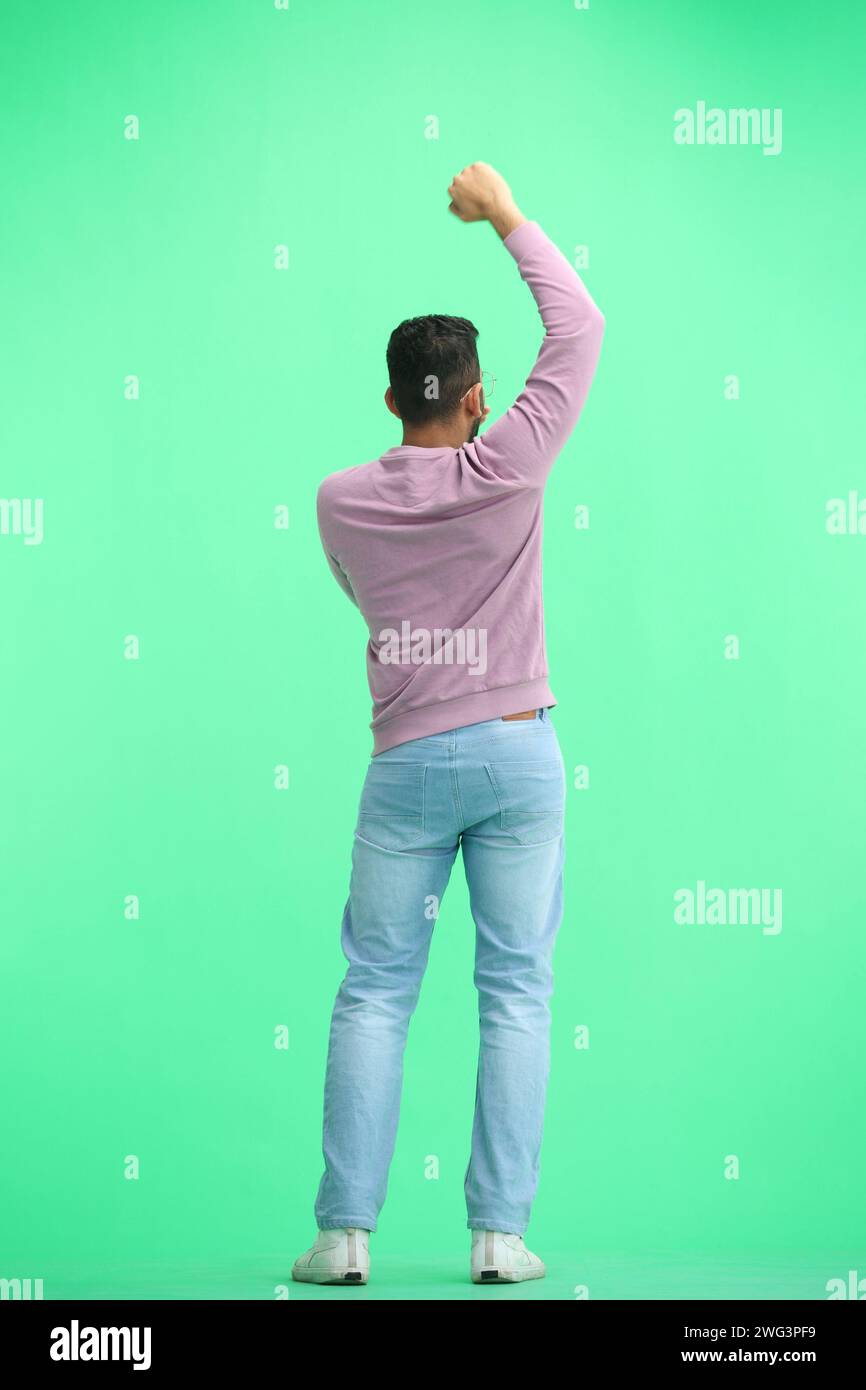A man, on a green background, in full height, rejoice Stock Photo - Alamy