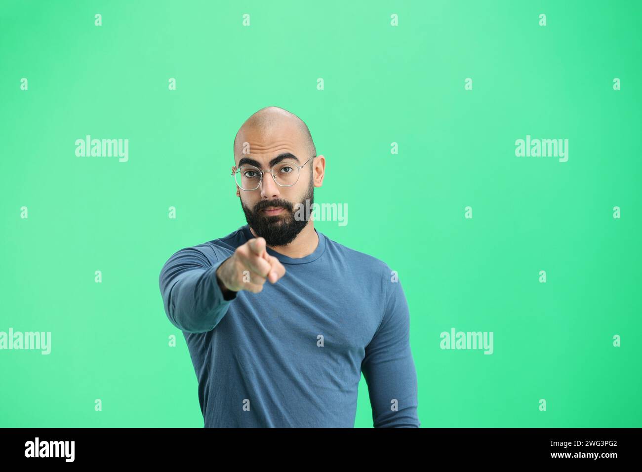 A man, on a green background, in close-up, points forward Stock Photo ...