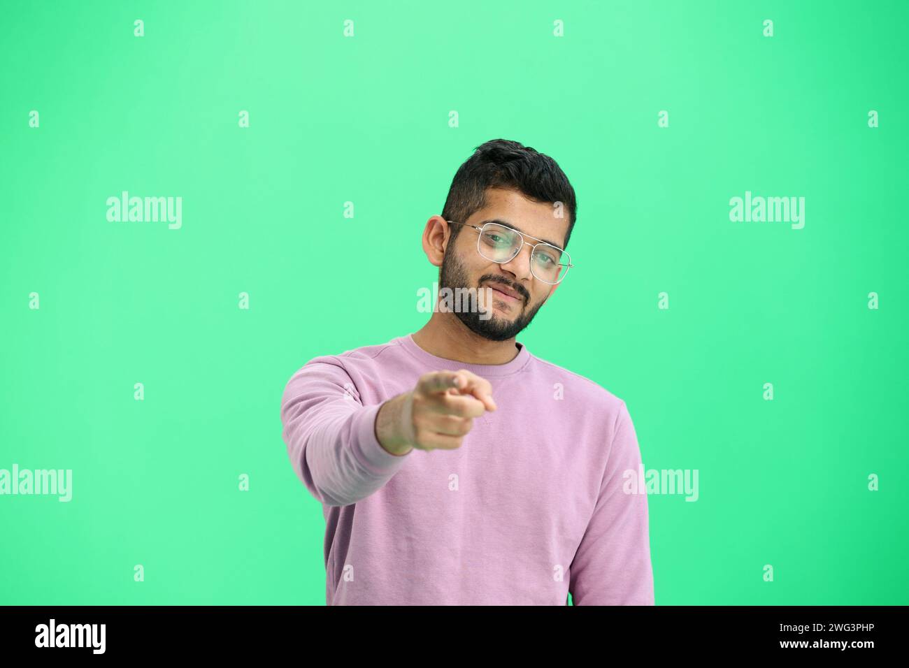 A man, on a green background, in close-up, points forward Stock Photo ...