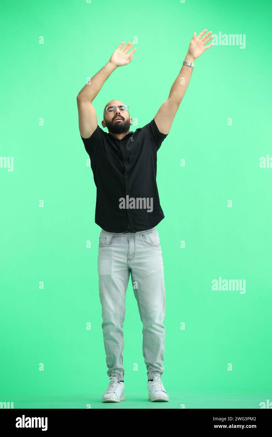 A man, on a green background, in full height, waving his arms Stock ...
