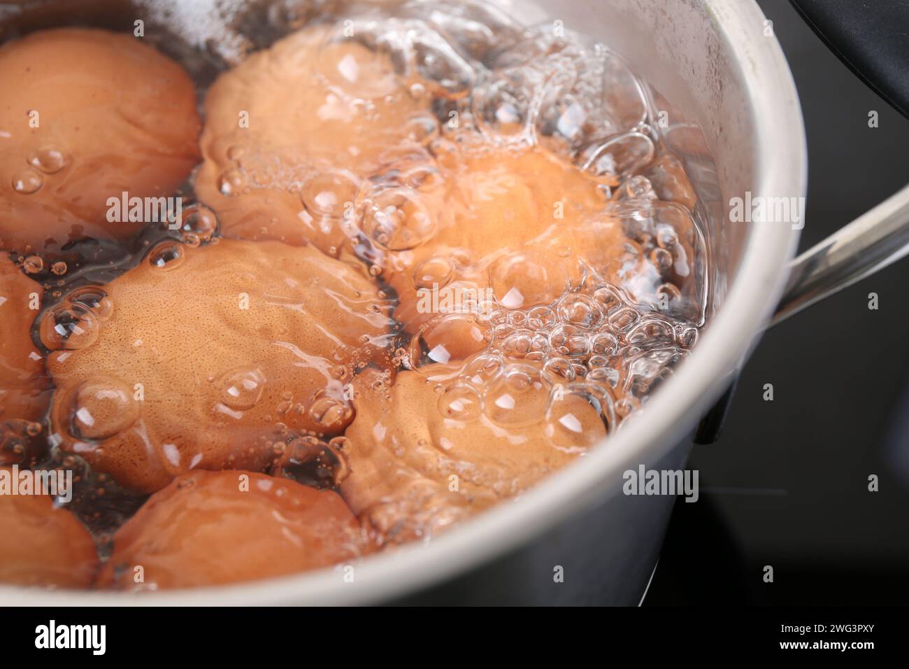 Chicken eggs boiling in pot on electric stove, closeup Stock Photo - Alamy