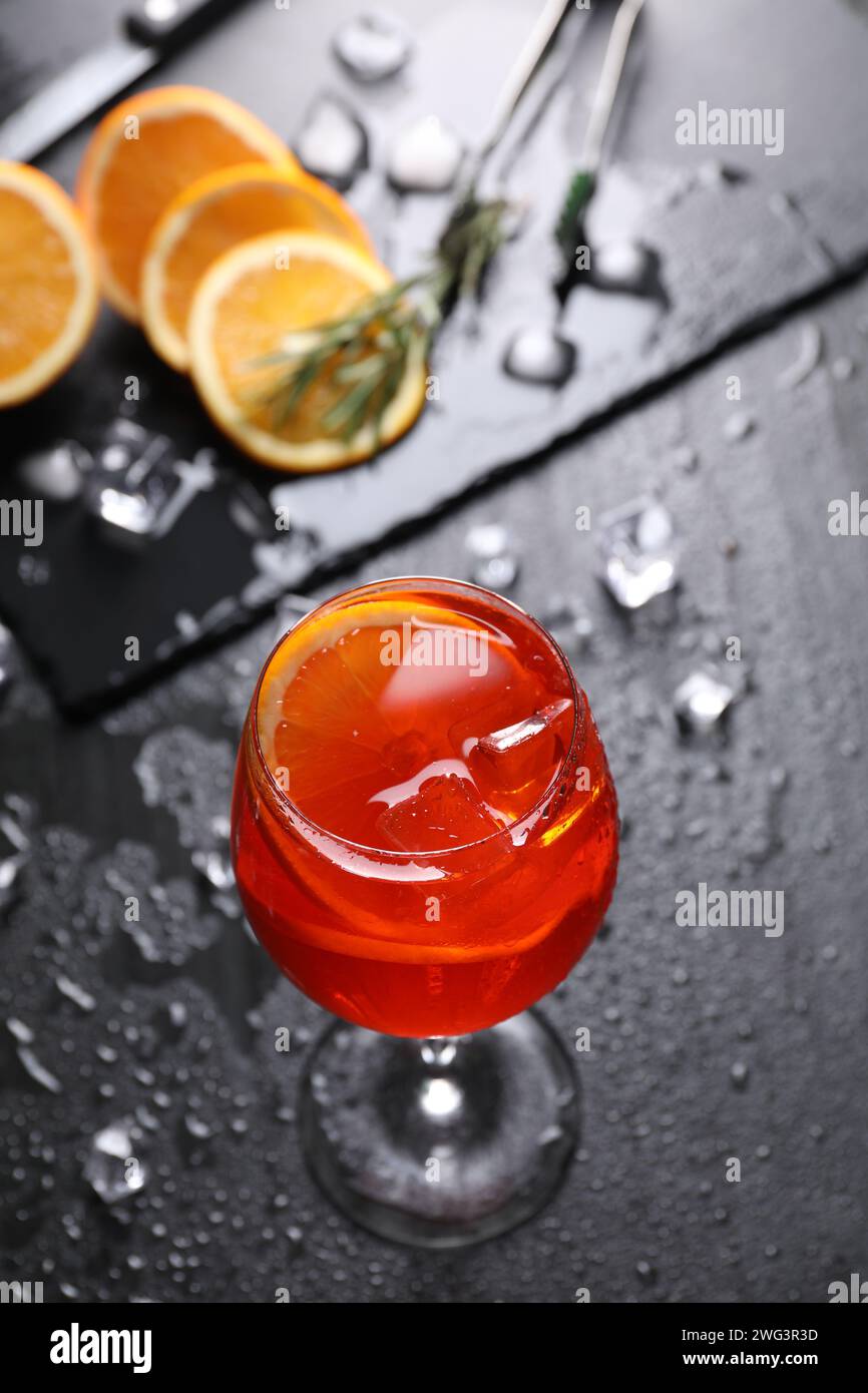 Glass of tasty Aperol spritz cocktail with orange slices and ice cubes ...